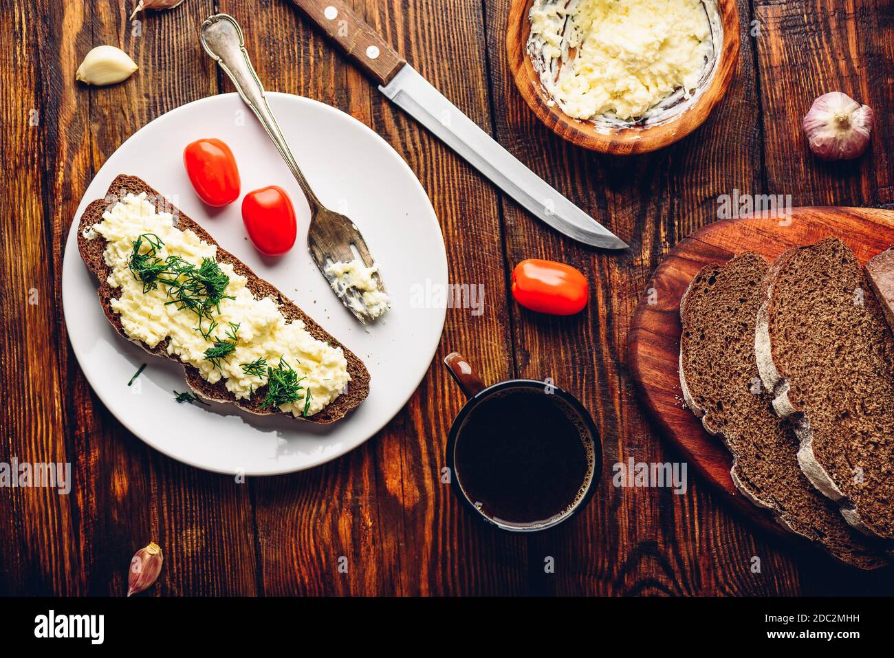 Rye bread toast with processed cheese and garlic on white plate. View ...
