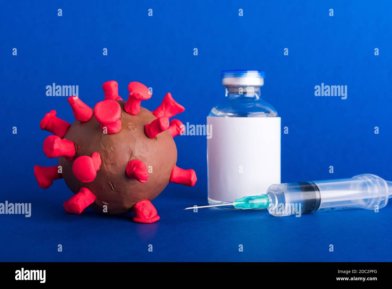 Closeup plasticine disease cells virus bottle vaccine and syringe of ...