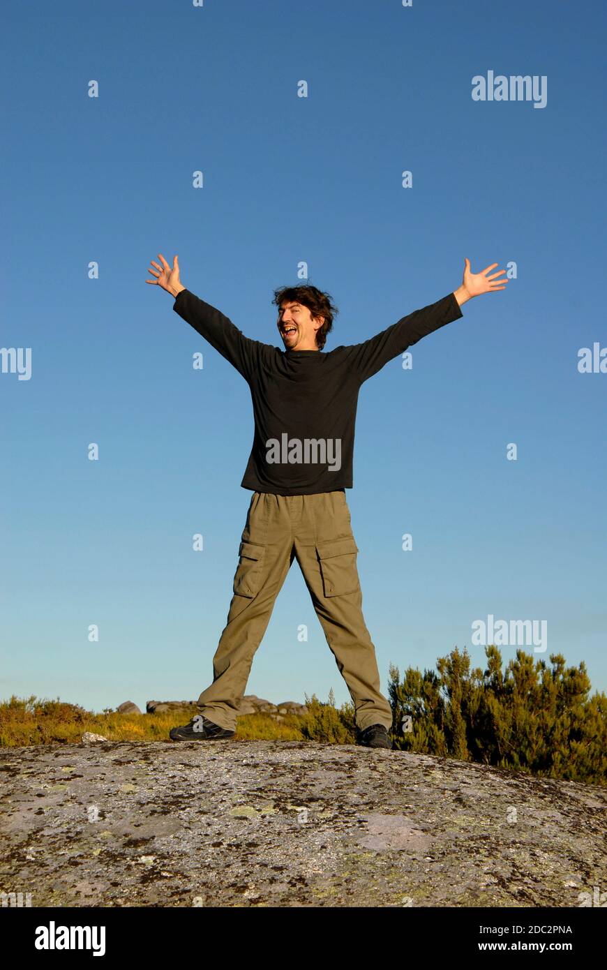 young man with arms wide open and the sky as background Stock Photo - Alamy
