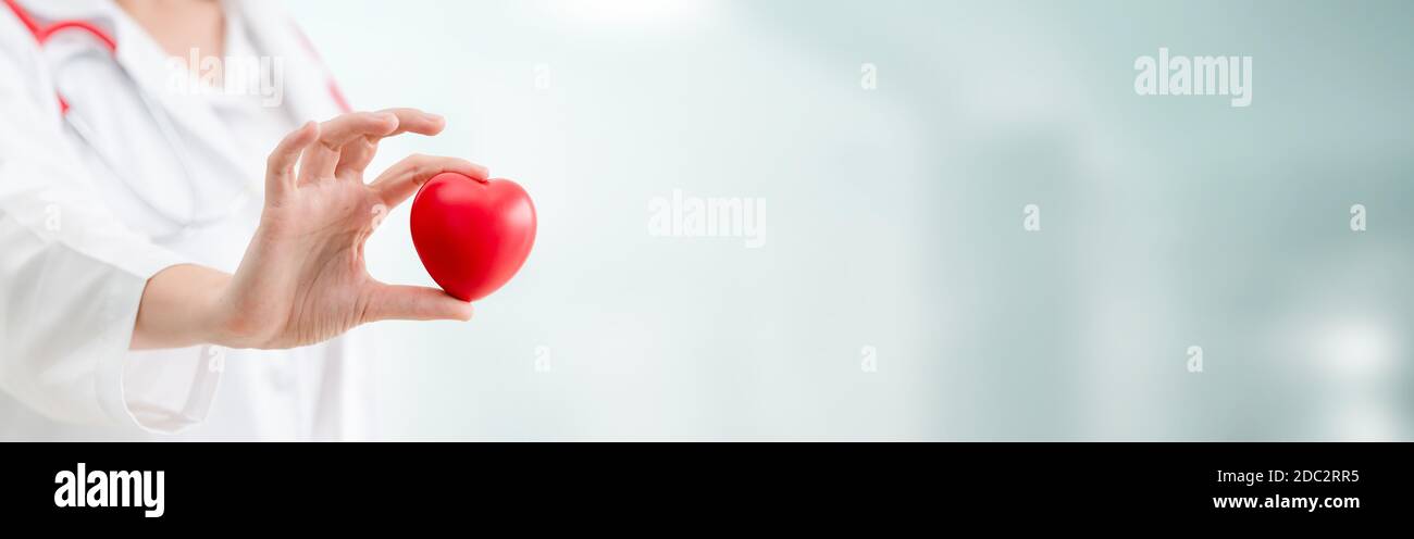 Doctor holding a red heart at hospital office. Medical health care and ...
