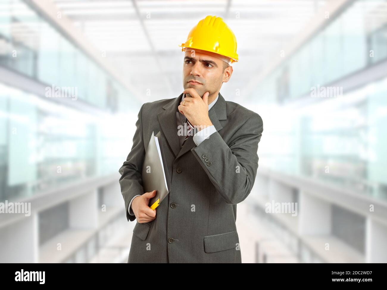 engineer thinking with yellow hat at the office Stock Photo - Alamy