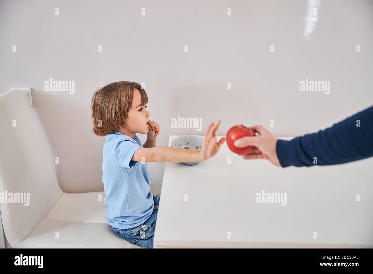 Adorable kid taking apple from his father while eating breakfast Stock ...