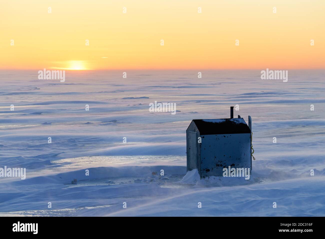 Ice fishing at sunset along the shores of Prince Edward Island, Canada ...