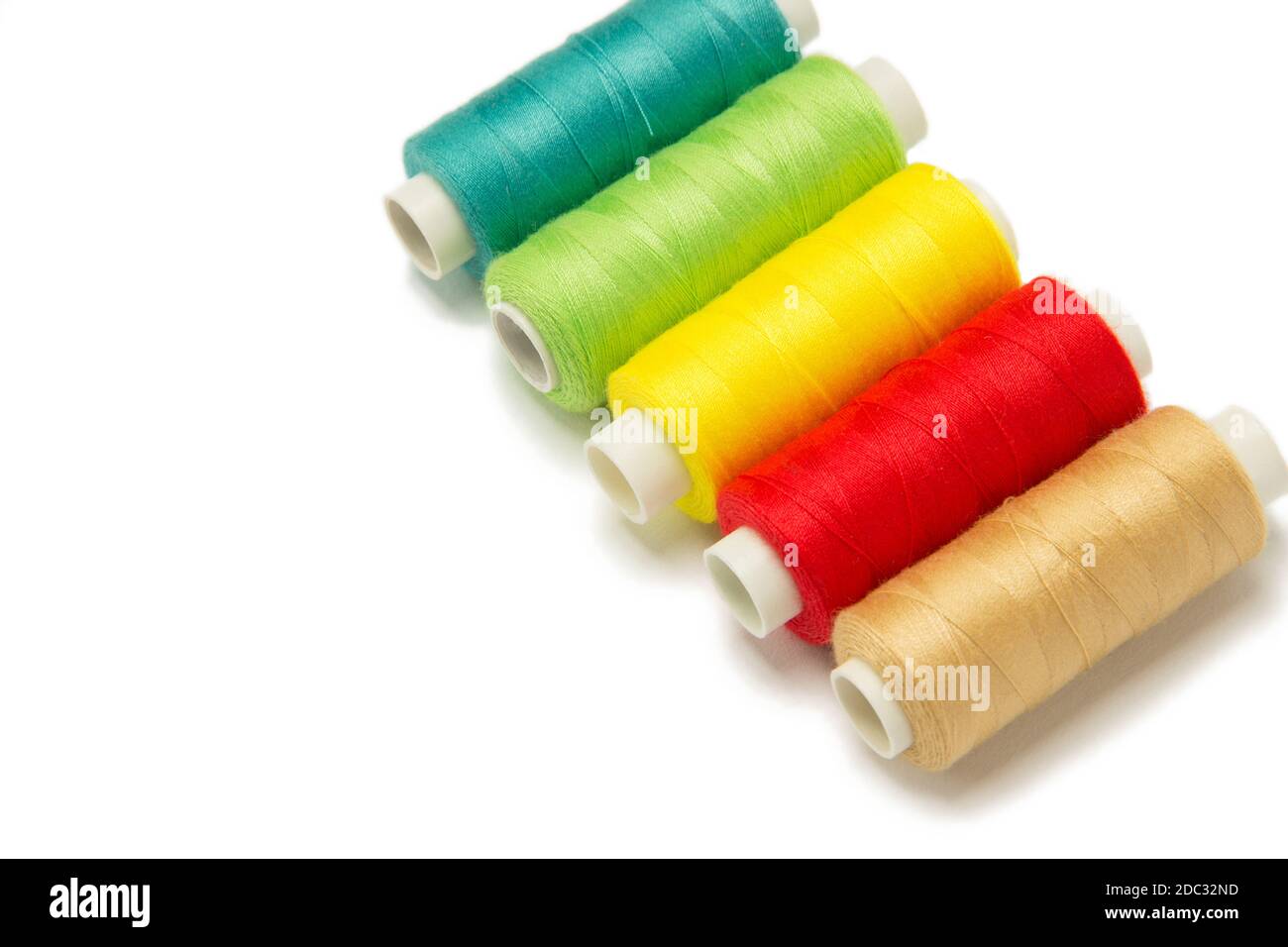 Closeup of red, yellow, golden and green sewing threads isolated on ...