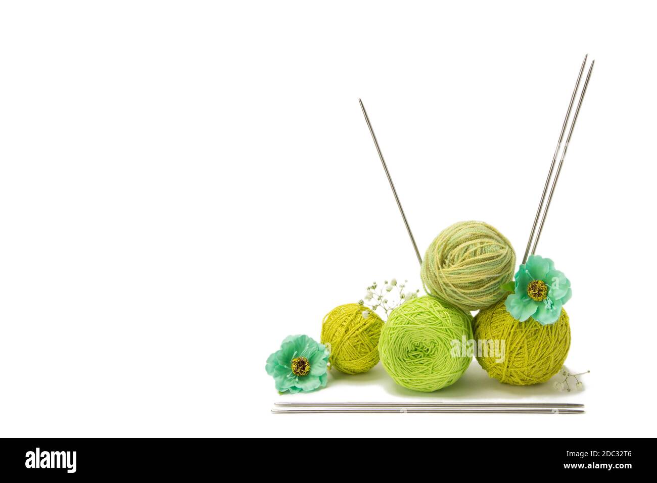 Green thread for knitting in tangles and metal needles with flowers on ...