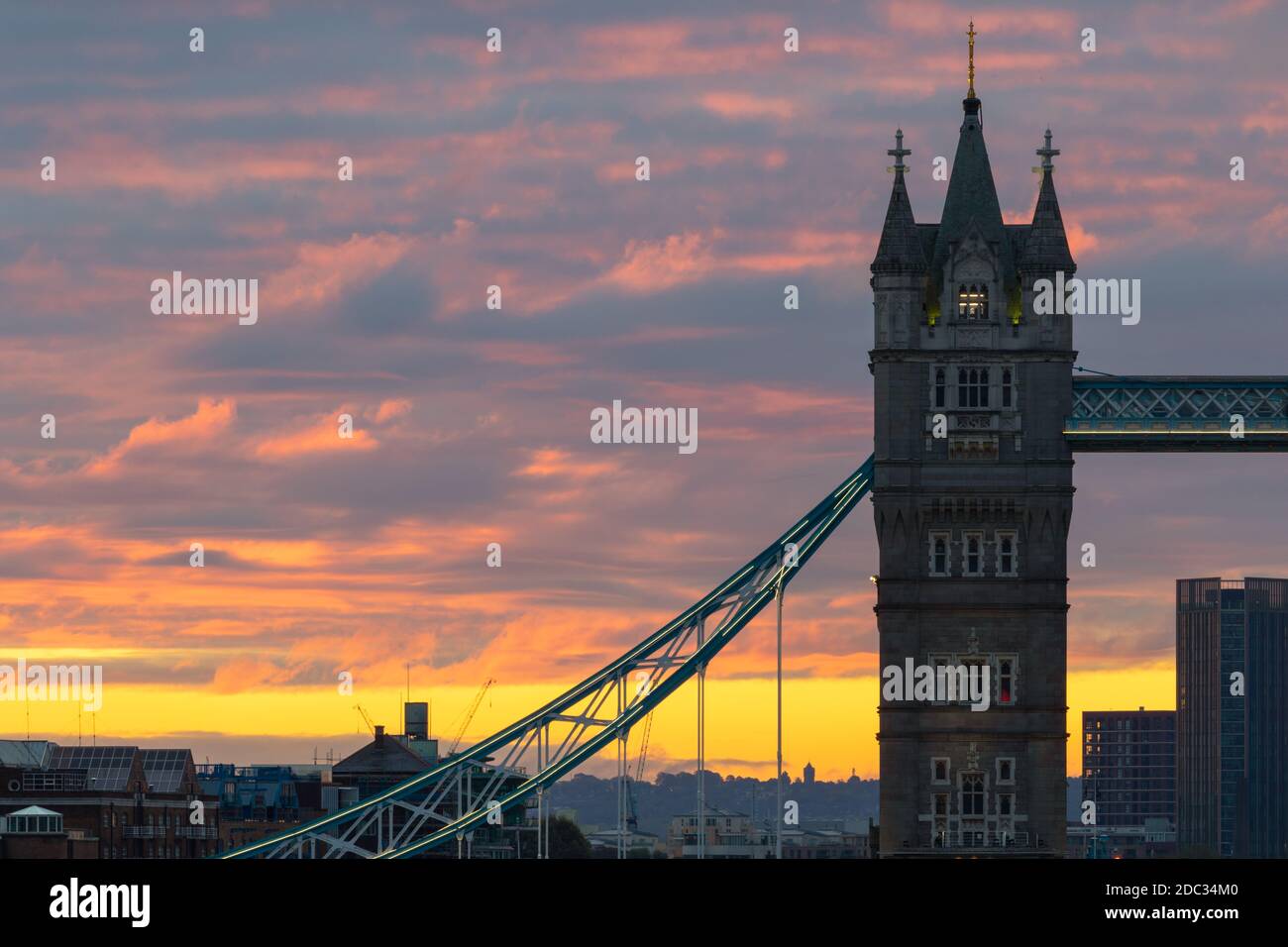 Close up of one tower of Tower Bridge against a morning sky with red ...
