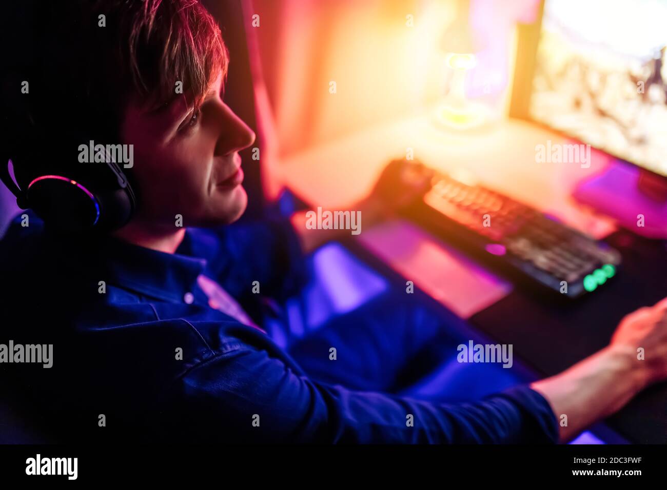 professional gamer playing computer games online with headphones, in a ...