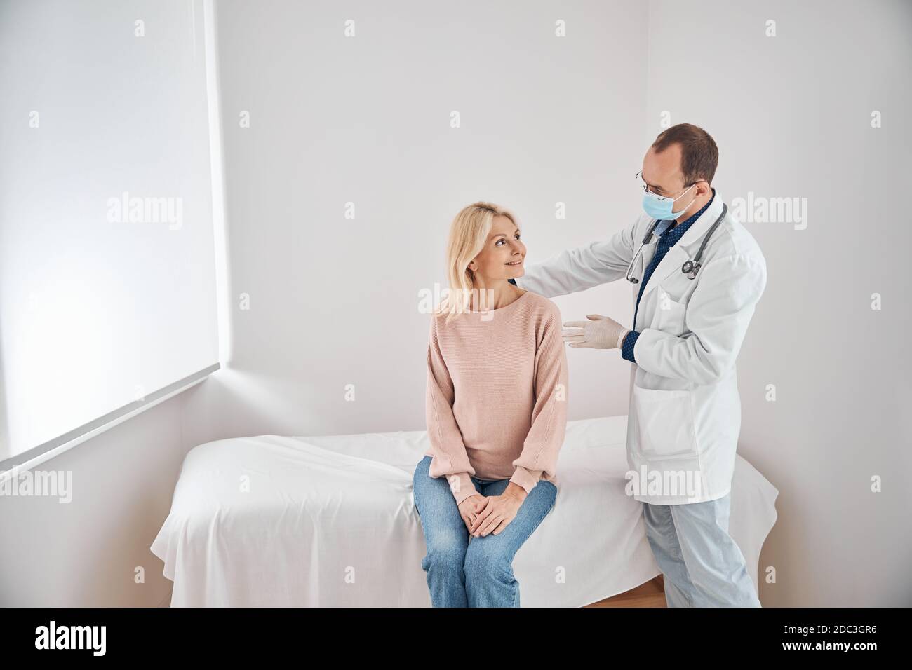 Experienced male doctor performing the spine examination Stock Photo ...