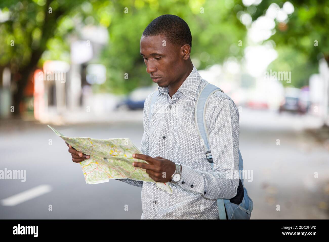 young tourist man looking for his landmarks with a map in the city ...