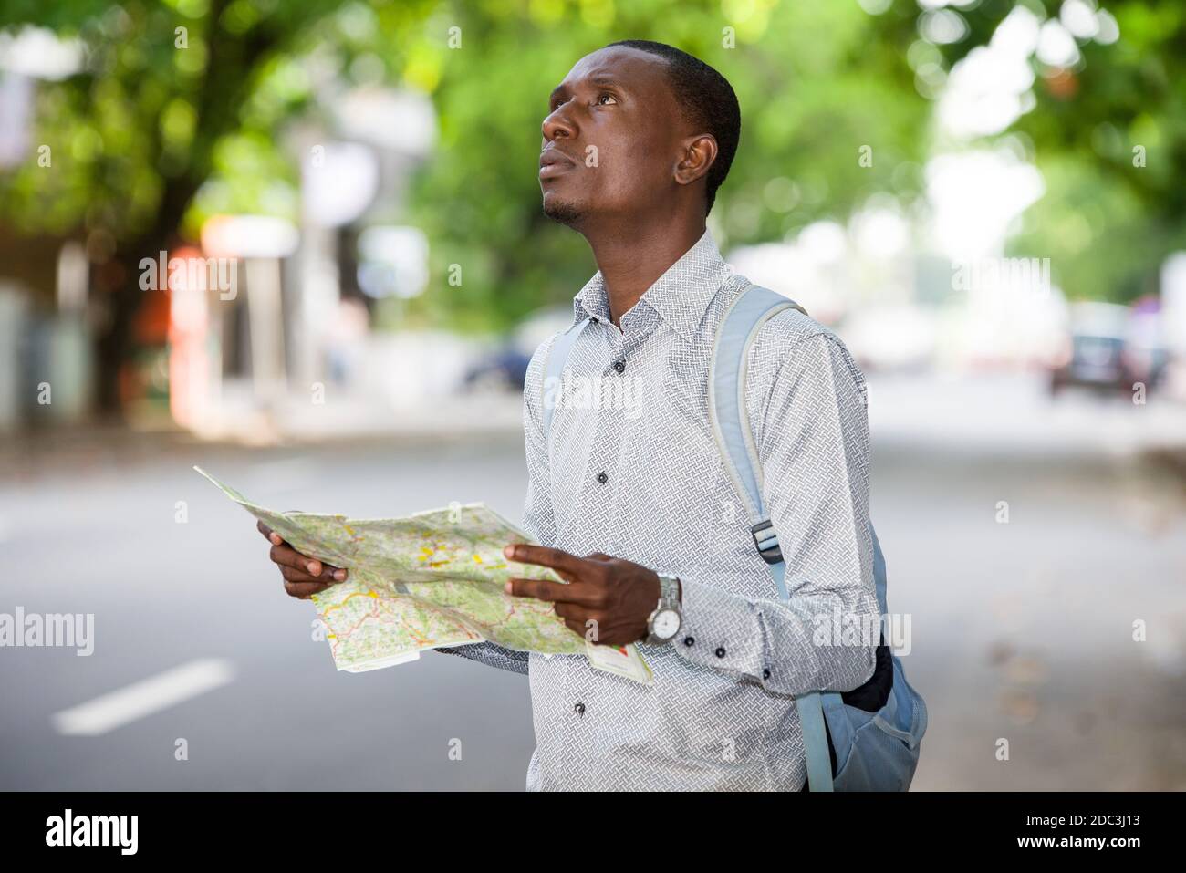 young tourist man looking for his landmarks with a map in the city ...