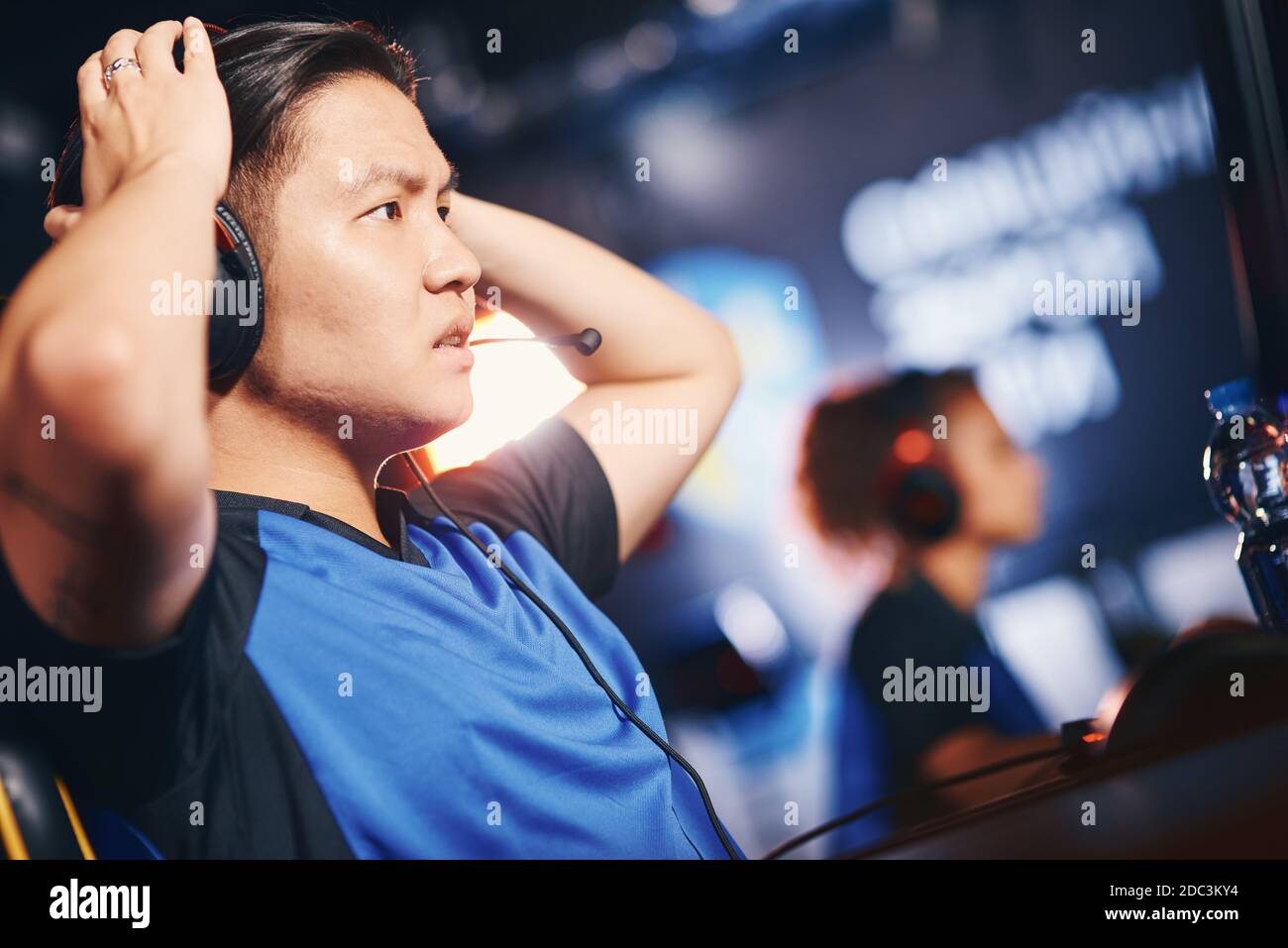 Side view of a confused asian guy, male cyber sport gamer wearing ...