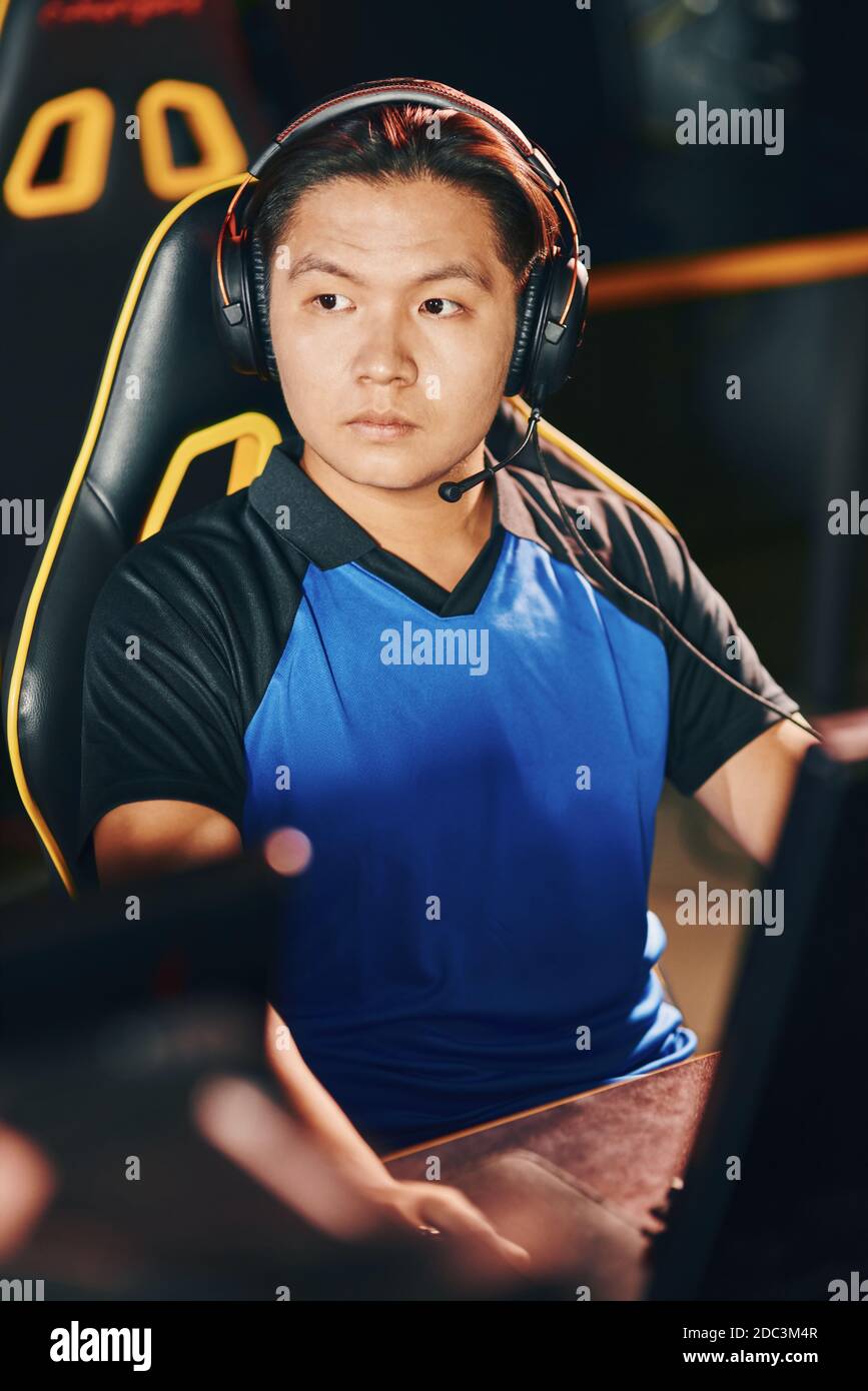 Professional cybersport gamer. Portrait of a young asian guy wearing ...