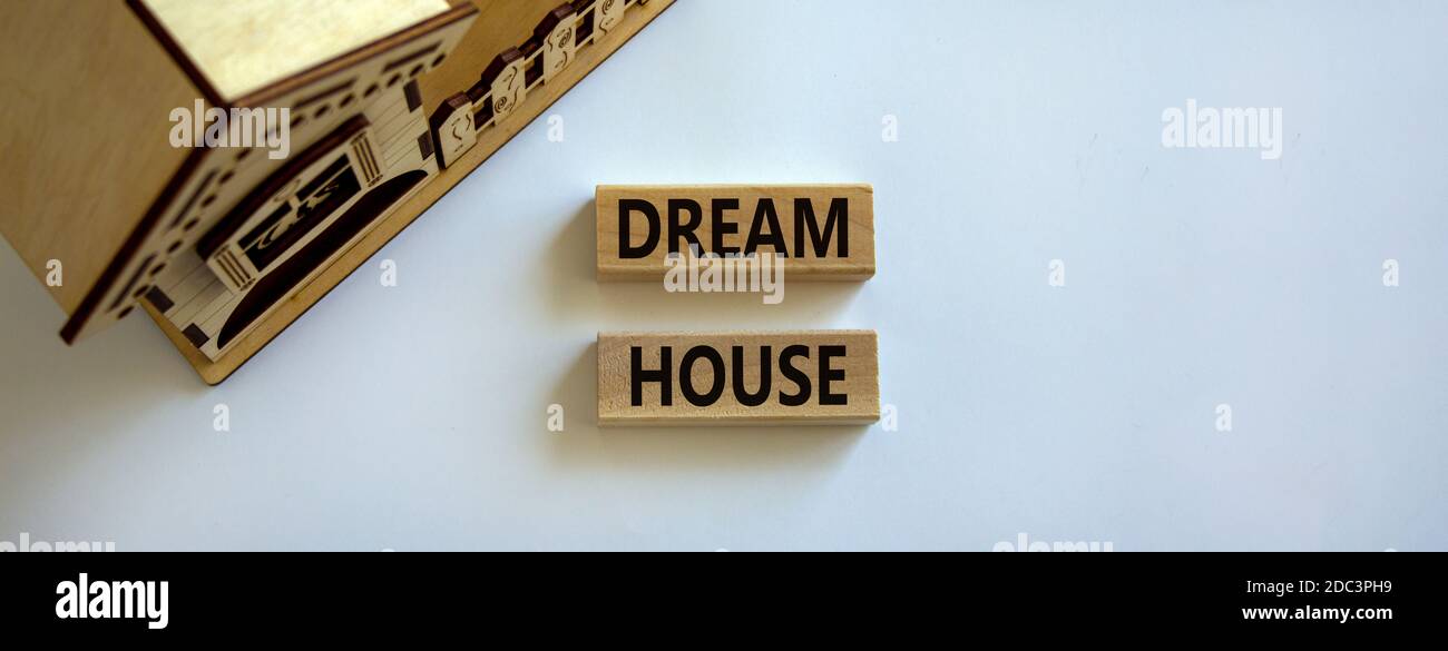 Wooden blocks form the words 'dream house' near miniature house ...