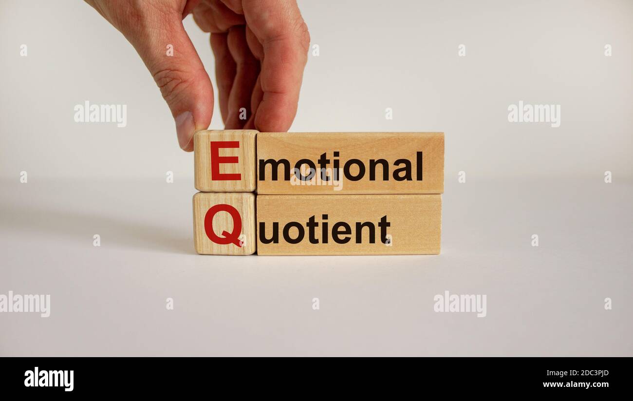 Wooden cubes and blocks with words 'EQ - emotional quotient'. Male hand ...
