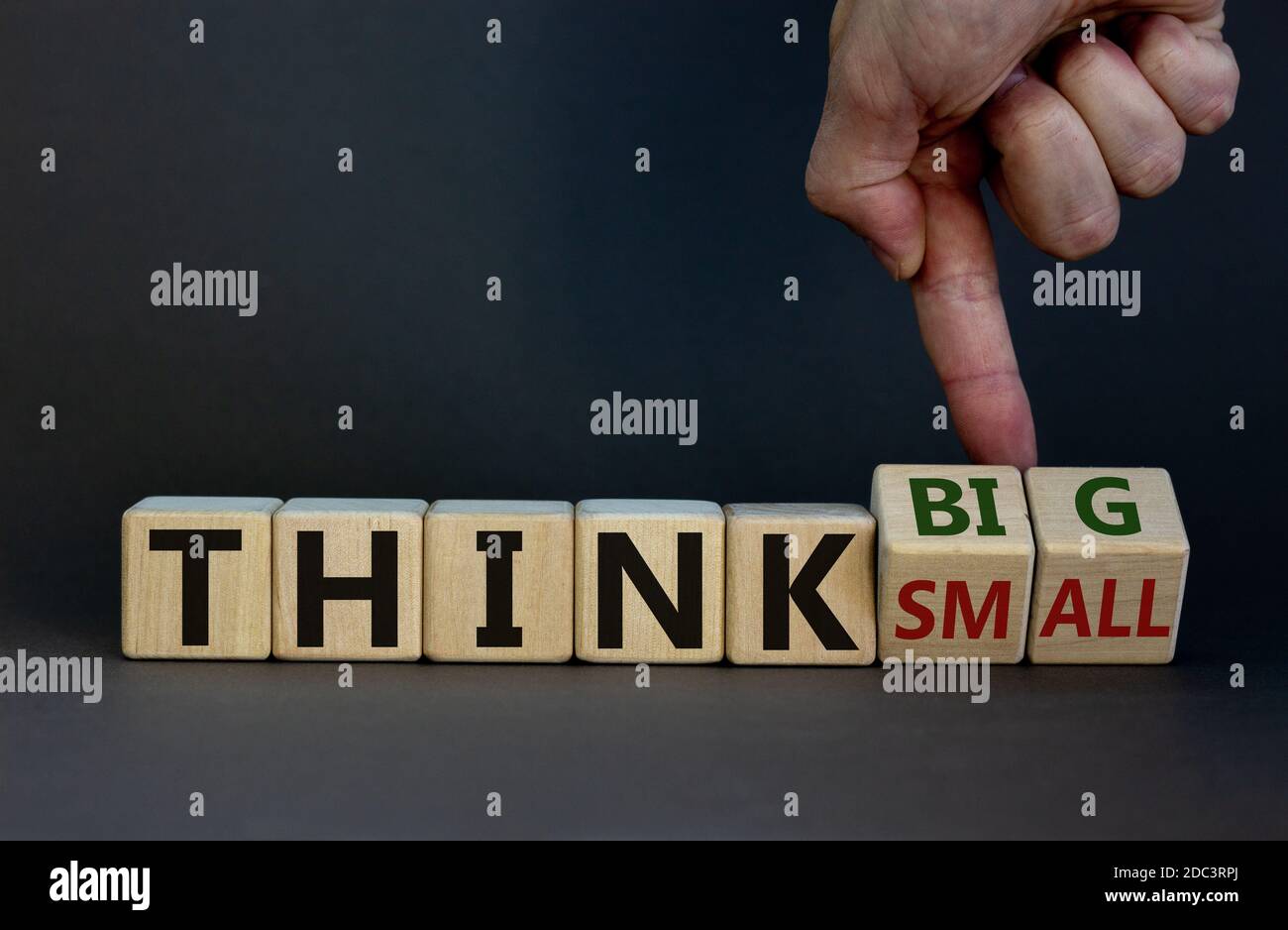 Think small or think big concept. Hand flips cubes and changes the ...