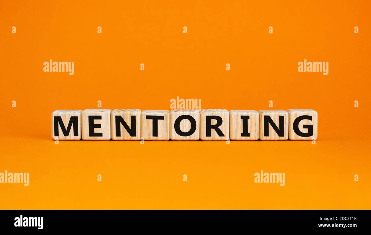 Wooden cubes with the expression 'mentoring'. Beautiful orange ...