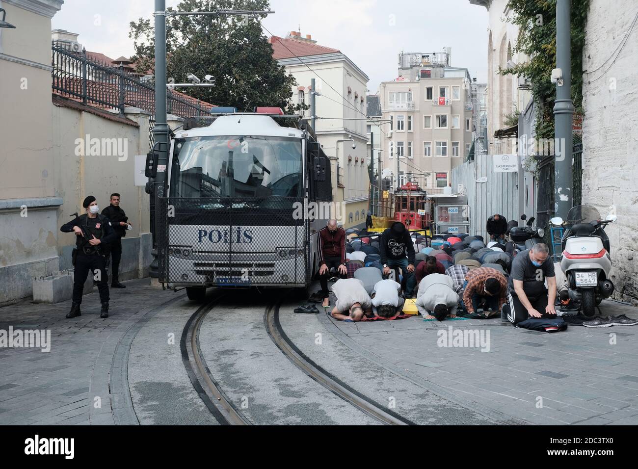 An armed Turkish policeman stands guard as Muslim worshipers pray in ...