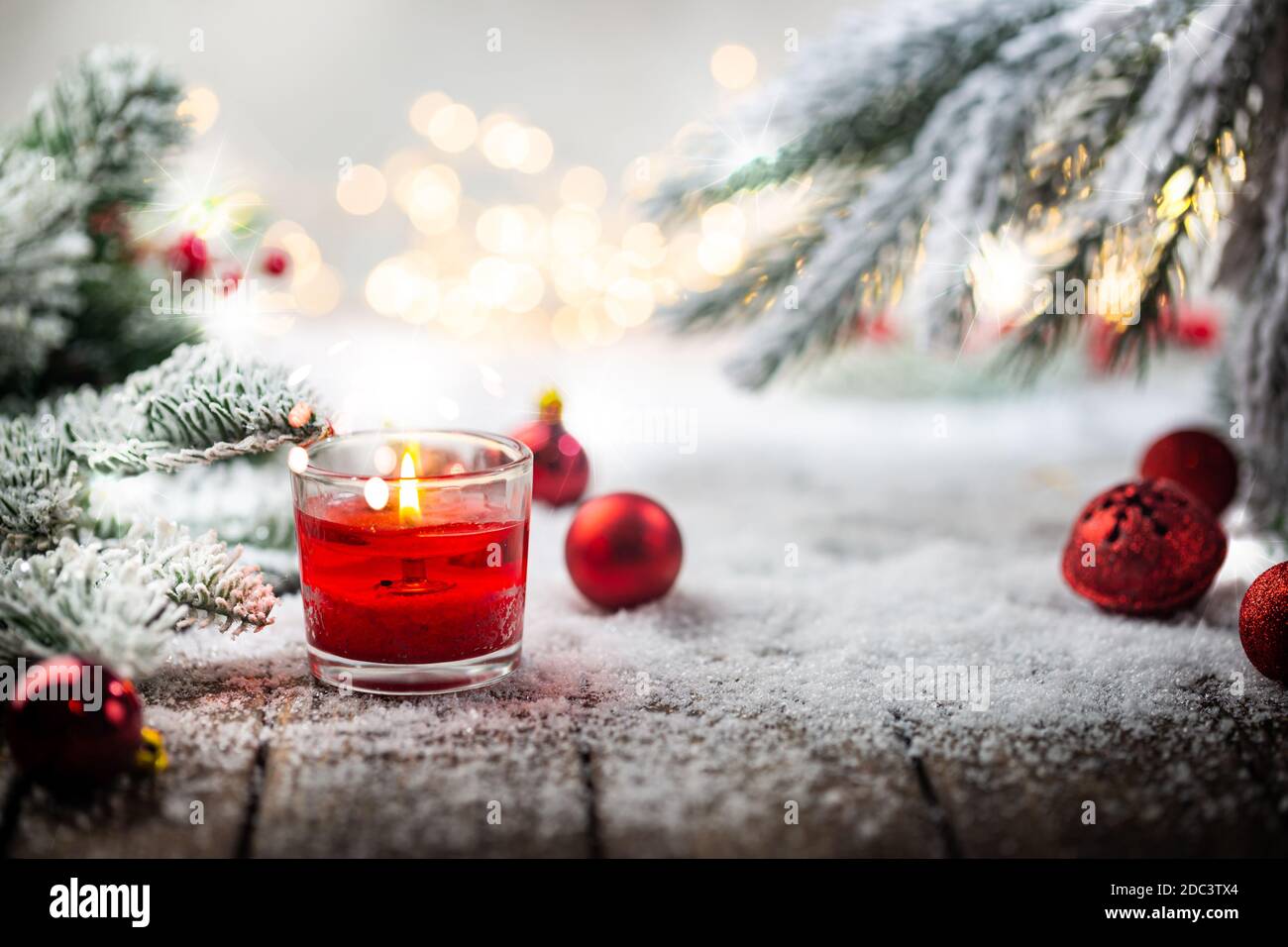 Christmas red decorations on snow with candle, fir tree branches and ...