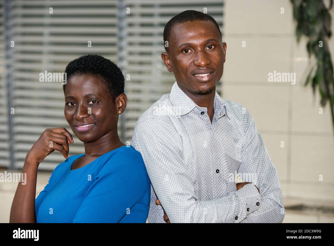 young couple standing staring at camera smiling Stock Photo - Alamy