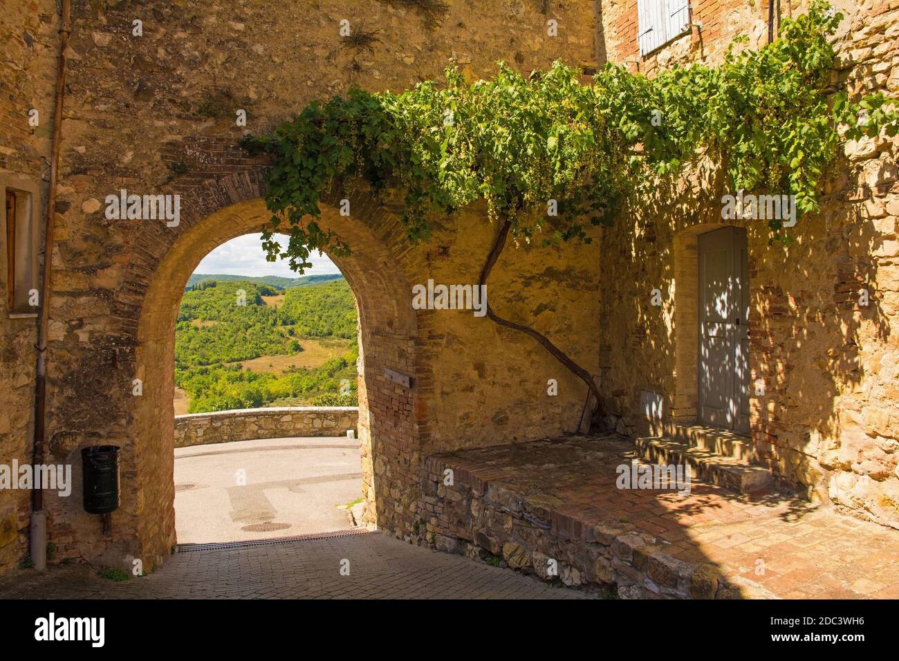 The arched main entrance to the historic village of Murlo, Siena ...
