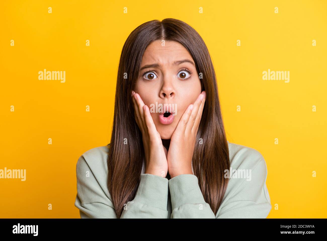 Photo of shocked impressed child girl dressed casual green outfit arms ...