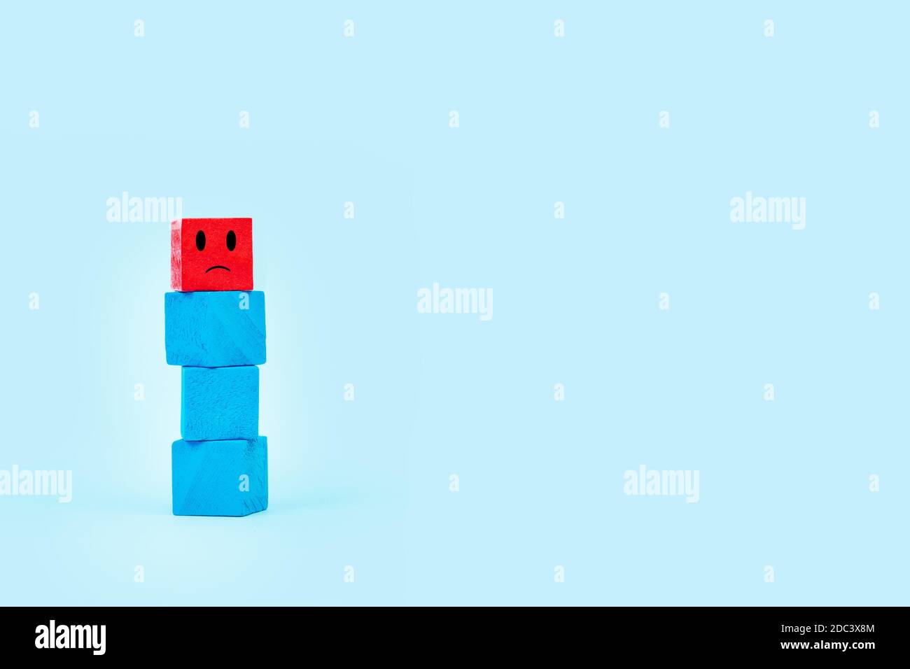 A human shape made with colored square wooden blocks on a light blue ...