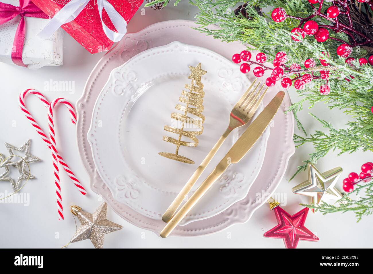 Christmas table setting with empty plates, gift box and xmas decor. Top ...