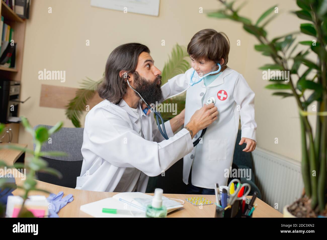 Paediatrician doctor examining a child in comfortabe medical office ...
