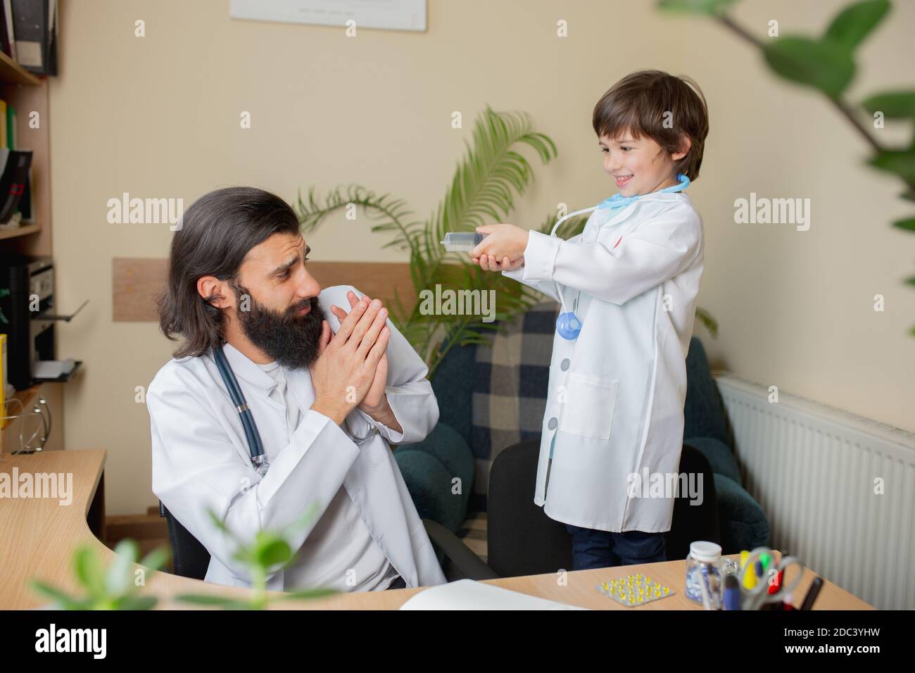 Paediatrician doctor examining a child in comfortabe medical office ...