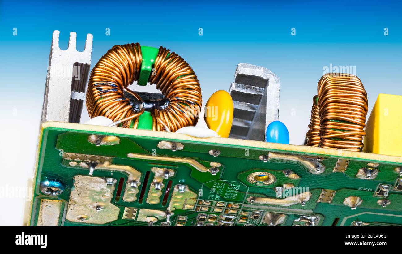 Toroidal electronic inductors soldered on circuit board. Copper wire ...