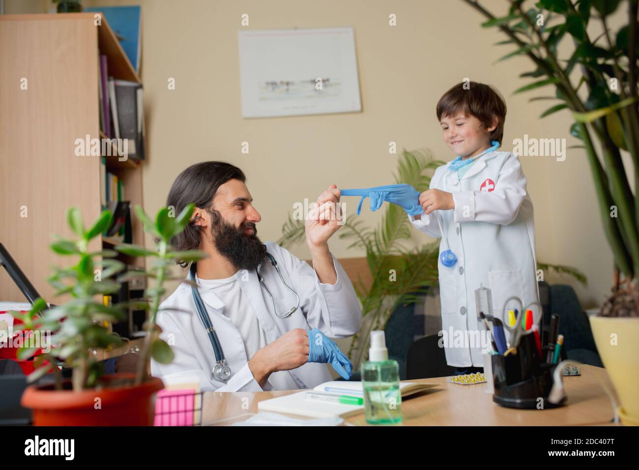 Paediatrician doctor examining a child in comfortabe medical office ...