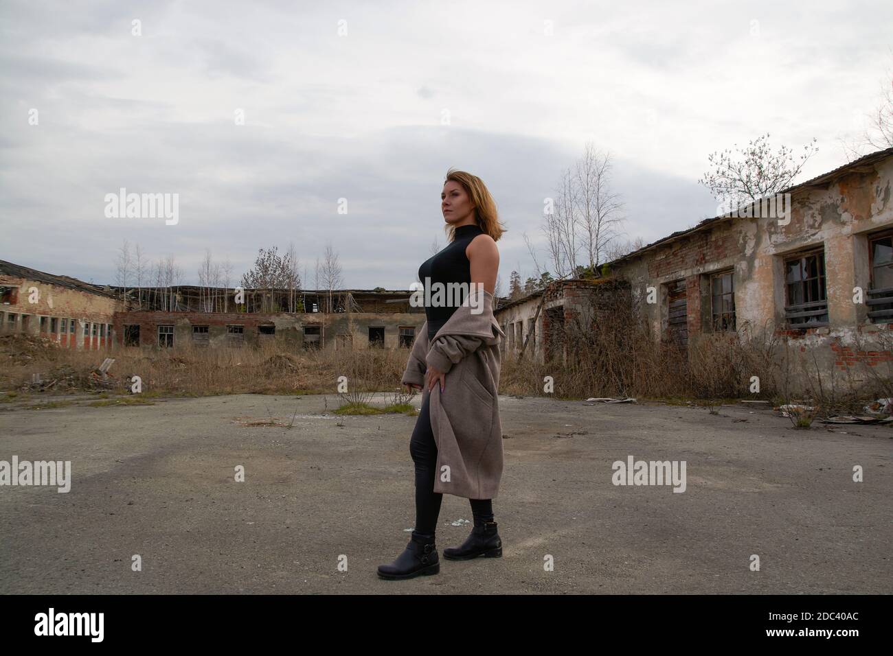 a woman on the ruins in a ruined city with garbage Stock Photo - Alamy