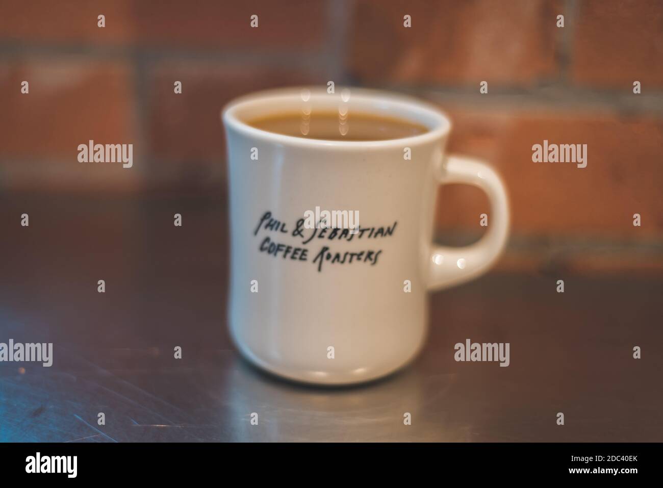Cup of coffee brick wall Stock Photo - Alamy