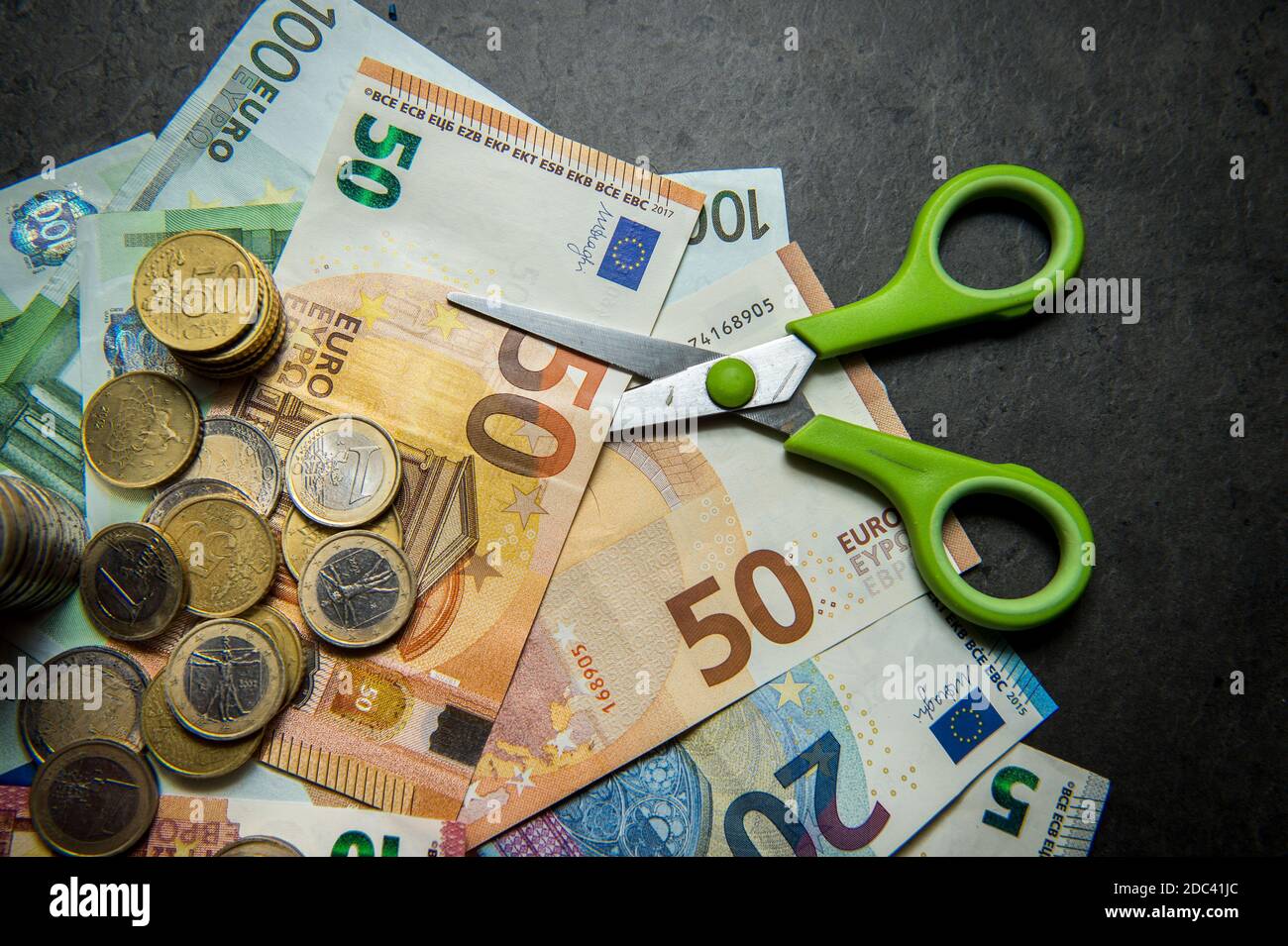 concept image with euro money cutting with scissors because of the ...