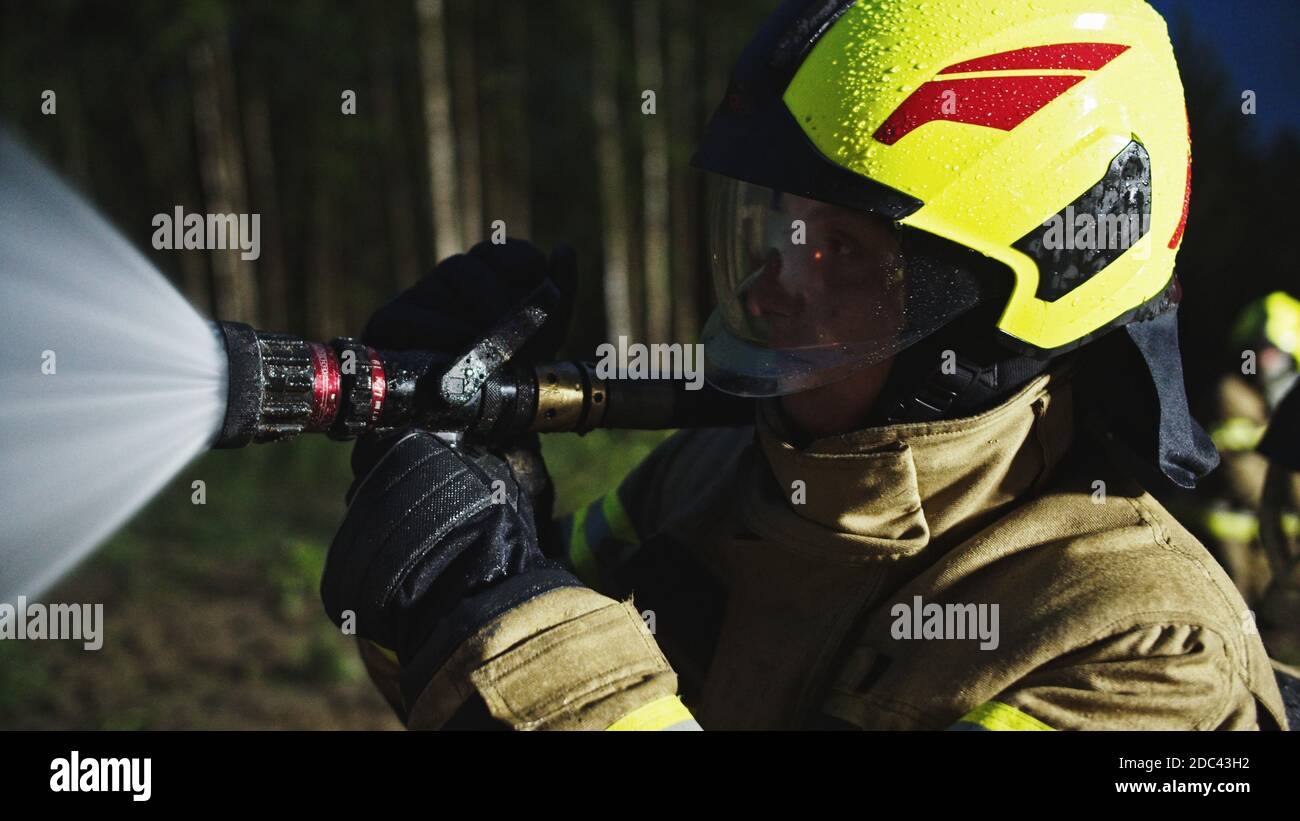 Fireman holding water hose hi-res stock photography and images - Alamy