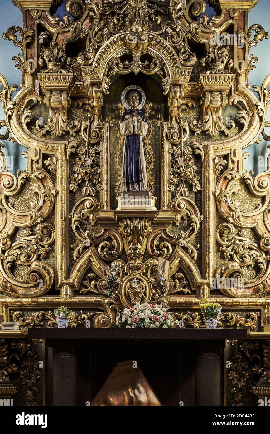 closeup of the altar and altarpiece with a saint, in a gothic niche in ...
