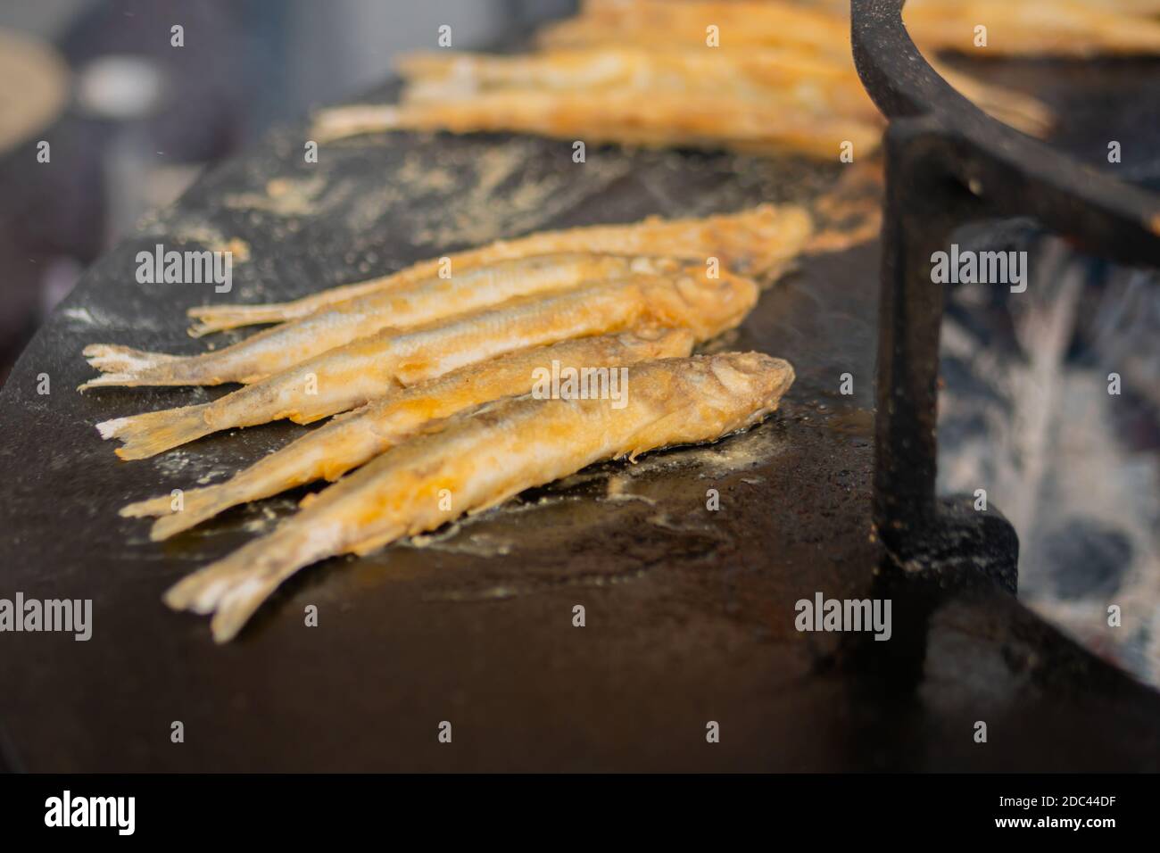 Process of cooking european smelt fish on black at food festival: close ...