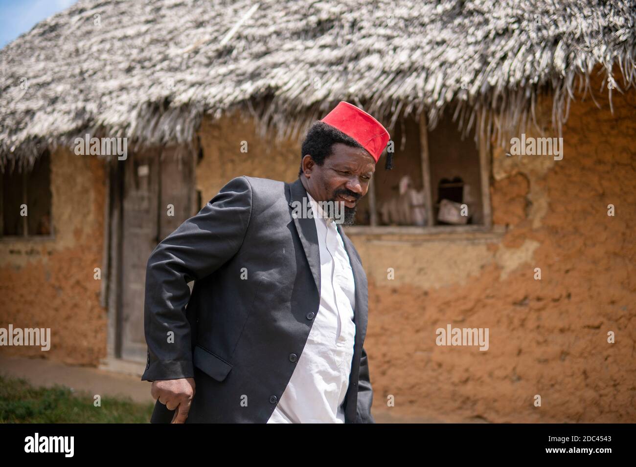 An African Older Man in Red Muslim Taqiyyah Fez Hat And Blazer Walking ...