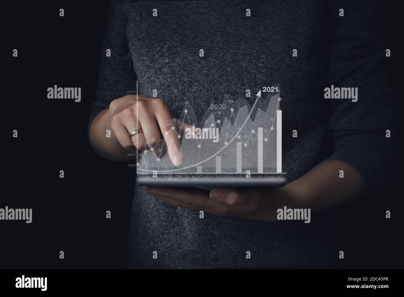 Virtual hologram of statistics, graph and chart with arrow up on hablet with women hand on dark ...