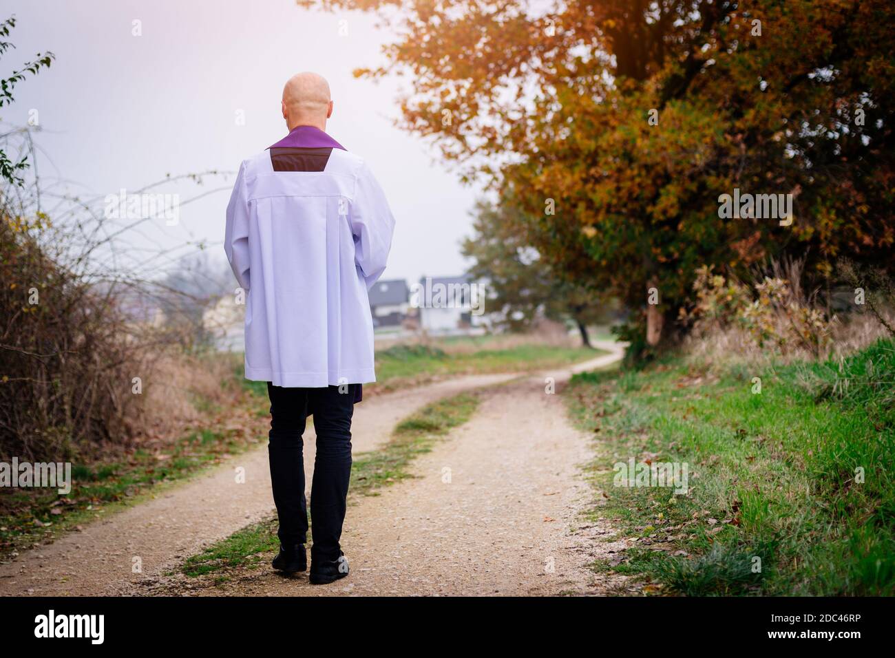 The figure of a priest from the back walking on a country road Stock ...