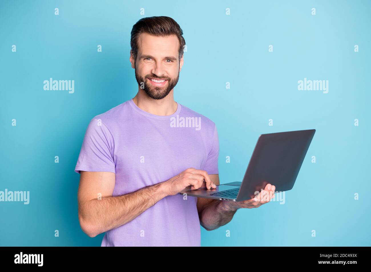 Photo portrait of smiling milennial keeping computer studying browsing ...