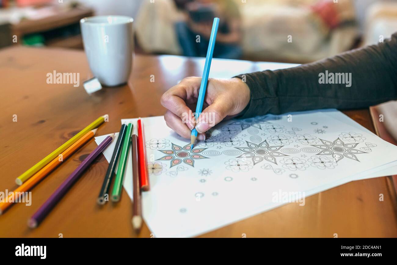 Detail of woman's hand coloring mandalas Stock Photo - Alamy