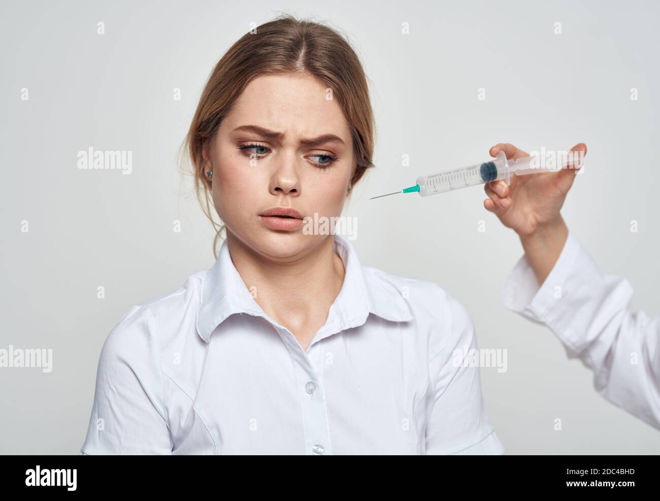 Syringe with liquid and a female patient in a white t-shirt health ...