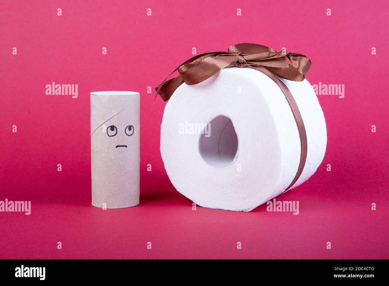 toilet paper roll with loop as present on red background, empty roll ...