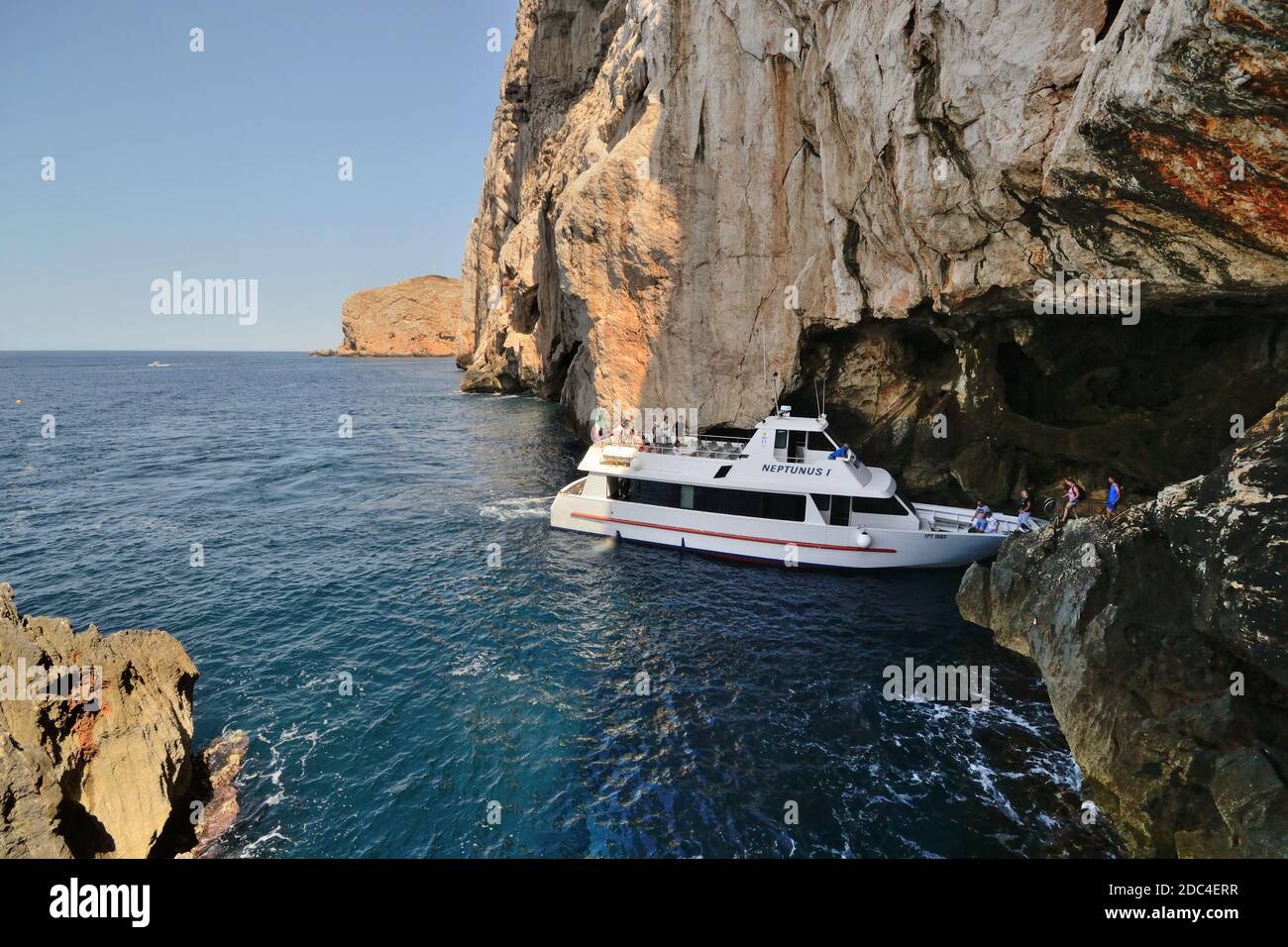 a ferry boat taking tourists to the Neptune's cave in the Capo Caccia ...