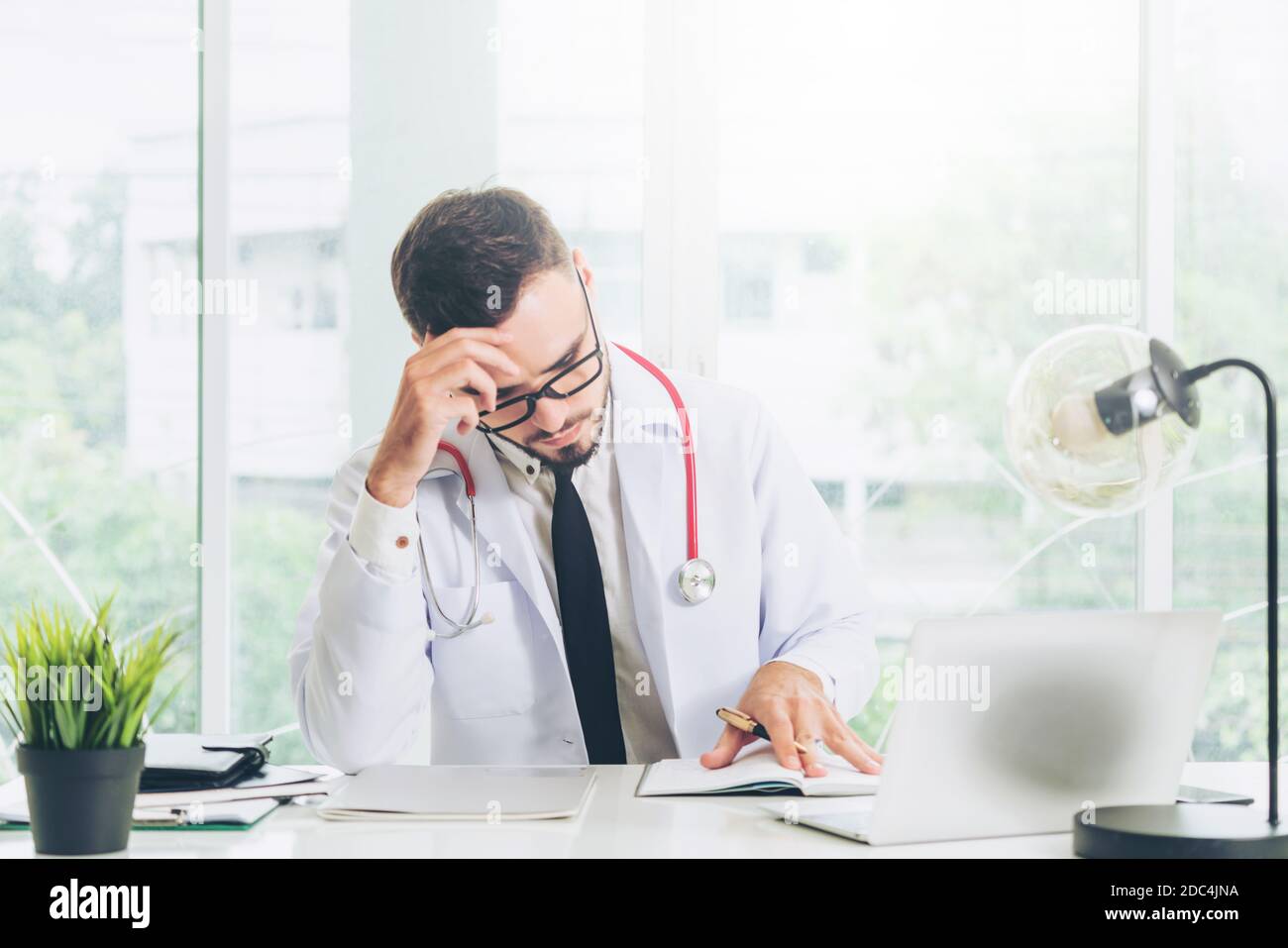 Doctor working on laptop computer at office table in the hospital ...