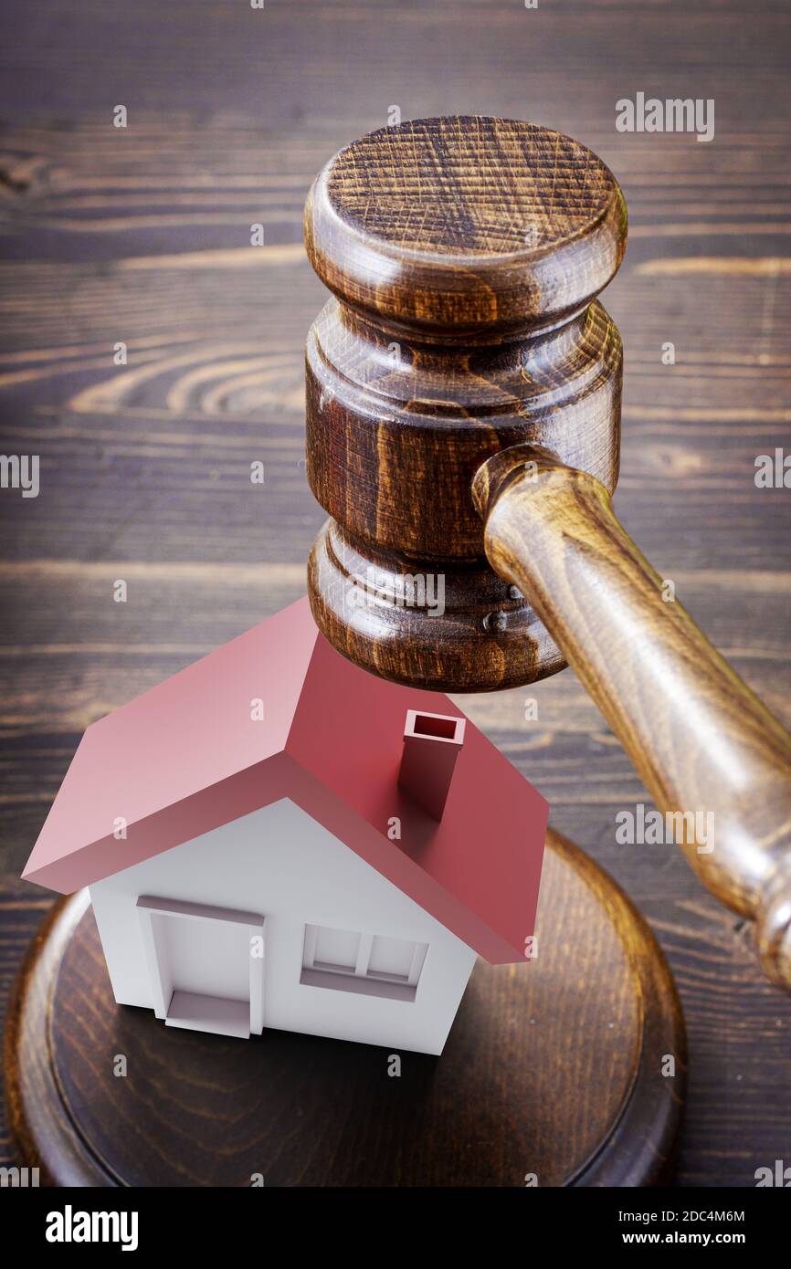 Gavel under small house Stock Photo - Alamy