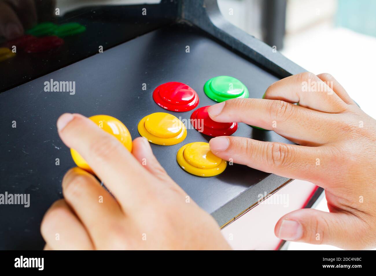 close-up hands pressing and holding joystick of old arcade video game ...