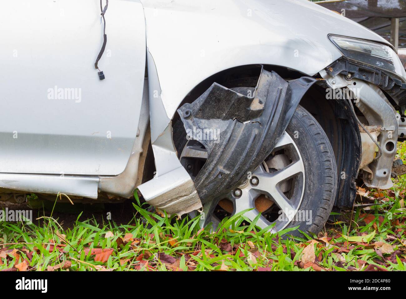 closeup damaged front wheel and bumper on green grass, safety concept ...