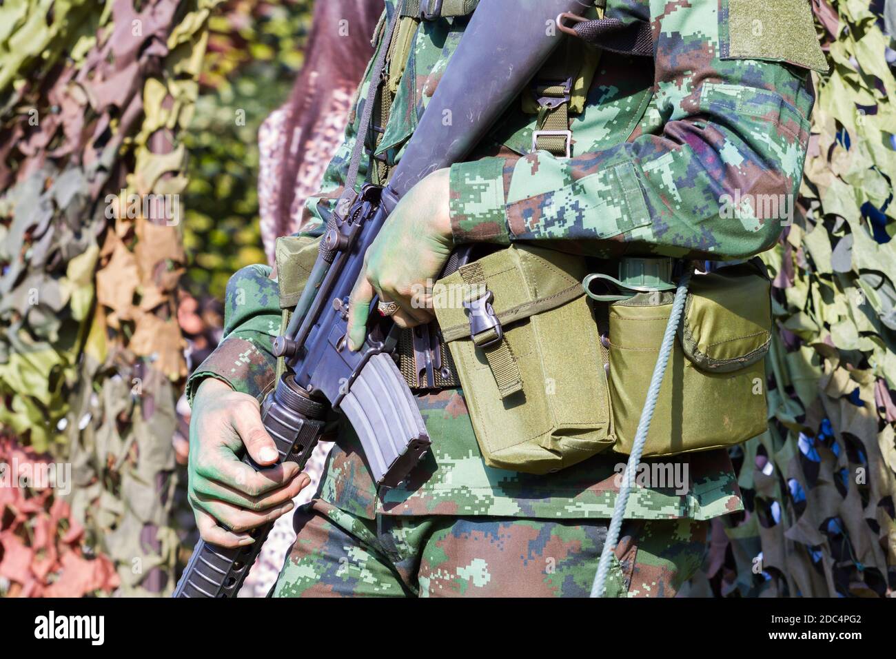 closeup male soldier hands holding machine gun, selective focus on hand ...